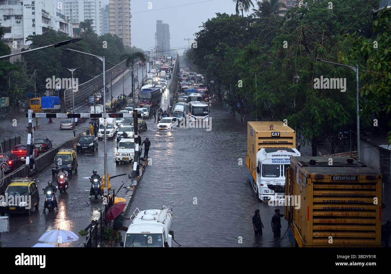 MUMBAI, INDIA - MAY 26: Vehicles wade through waterlogged road at Gandhi Market in the Sion area ...