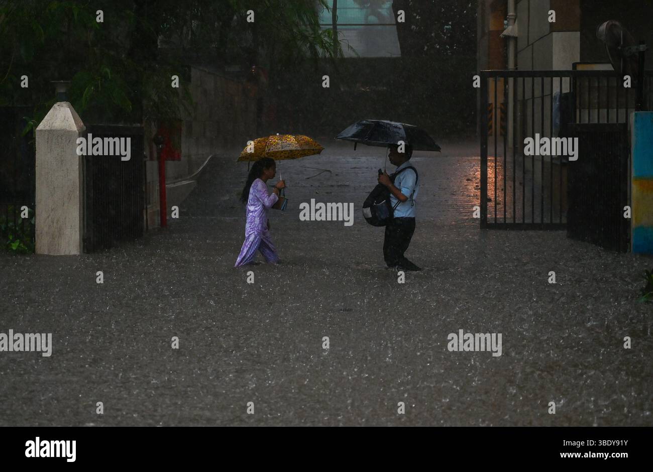 MUMBAI, INDIA - MAY 26: People wade through waterlogged road at Gandhi Market in the Sion area ...