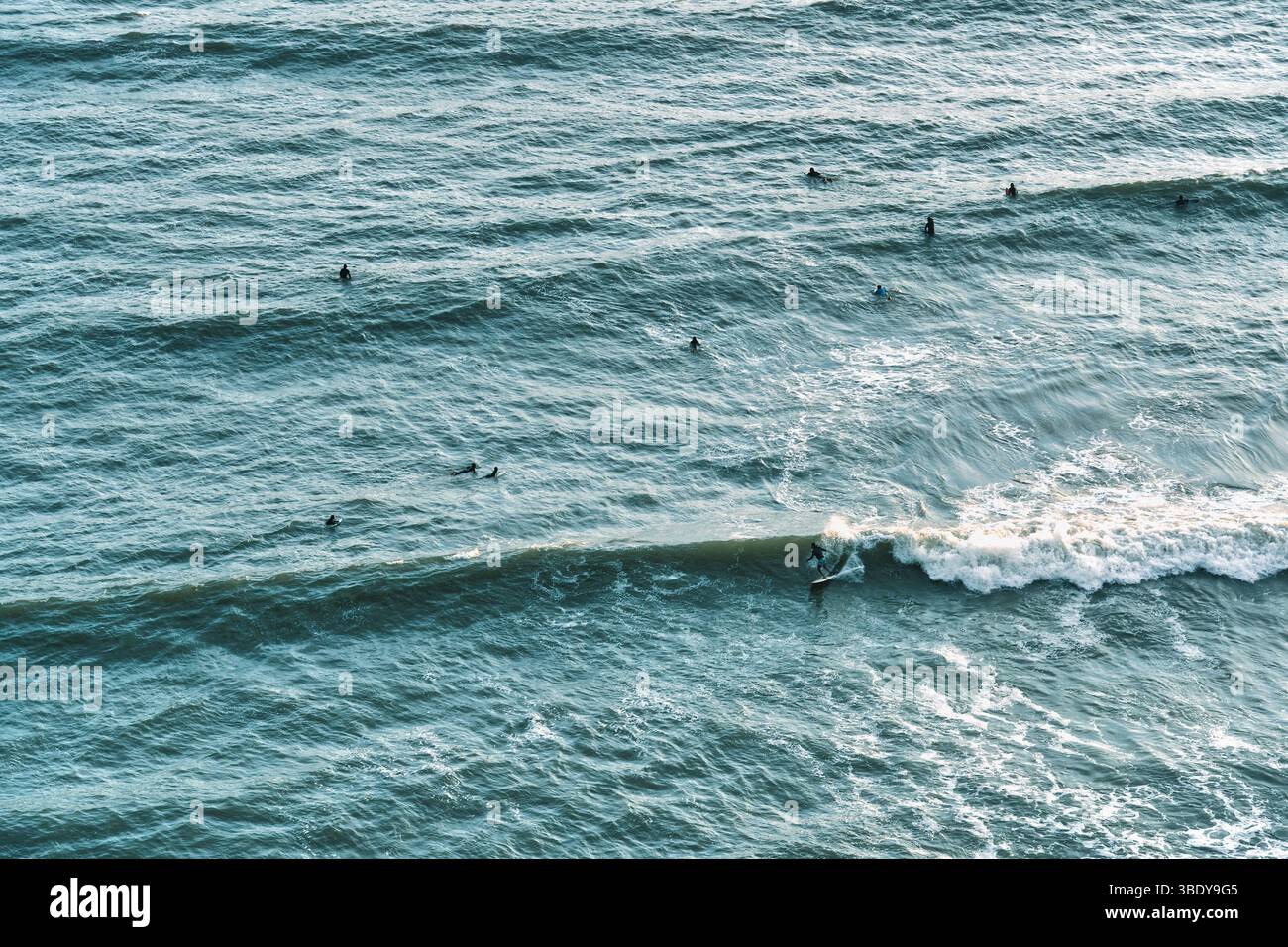 View from above with surfers riding the waves of the Pacific coast in ...