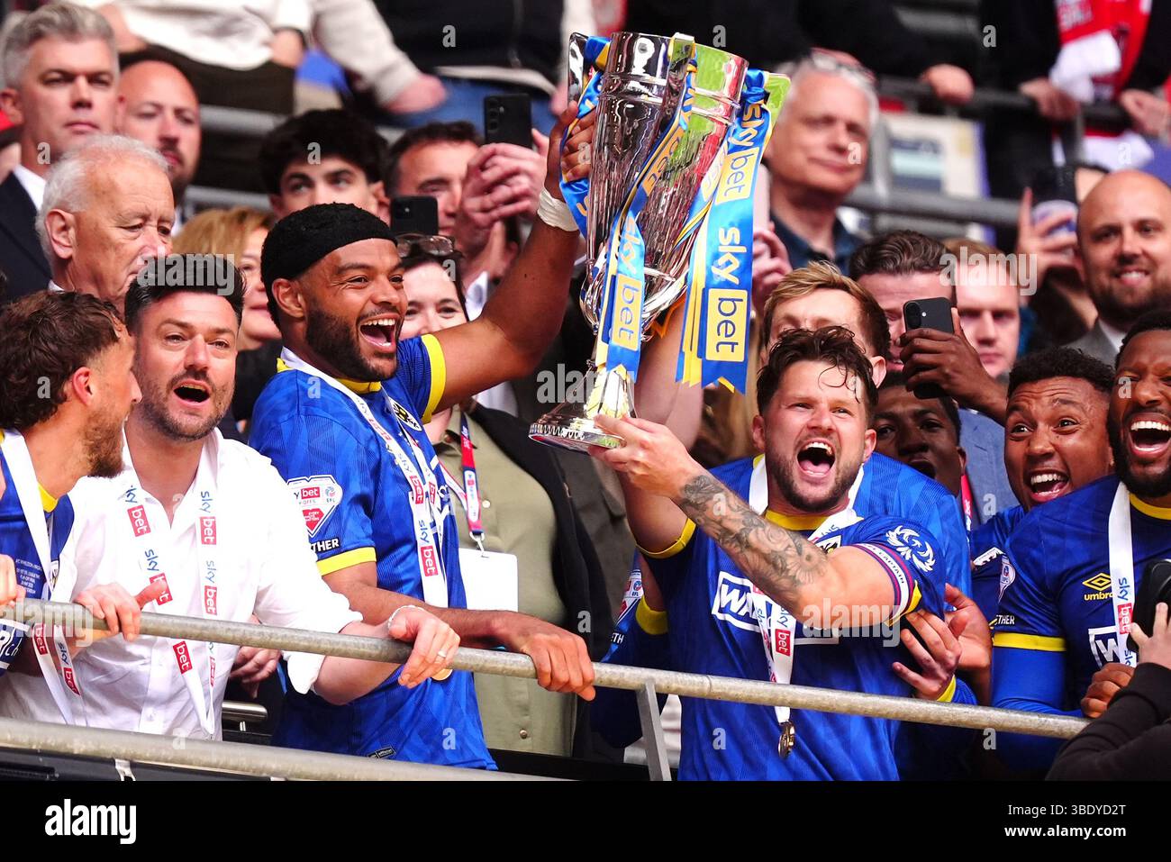 AFC Wimbledon's Ryan Johnson and Jack Reeves lift the trophy with team ...