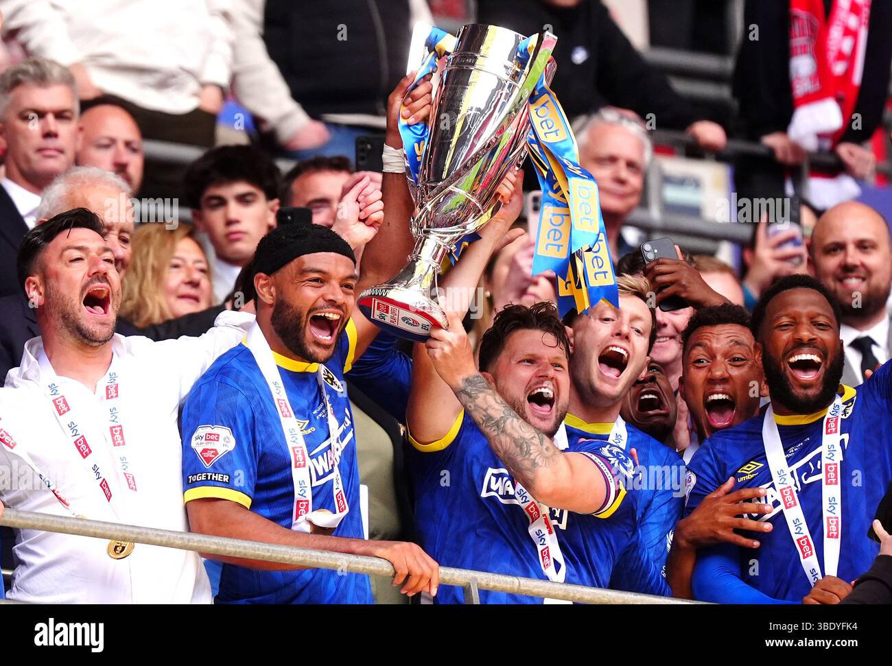 AFC Wimbledon's Ryan Johnson and Jack Reeves lift the trophy with team ...