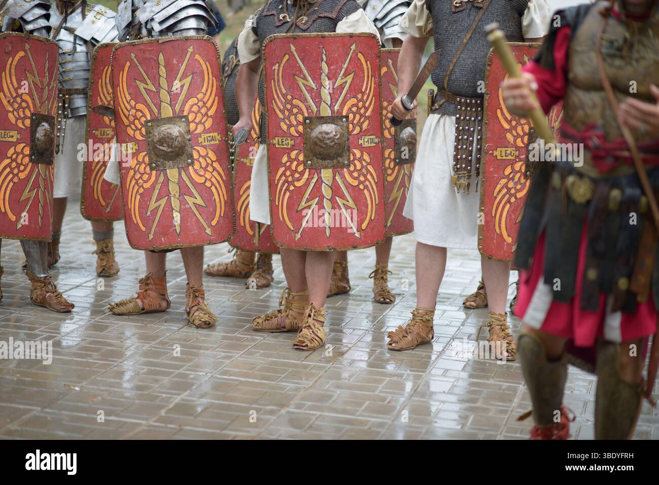 A group of reenactors dressed as Roman soldiers, holding large ...