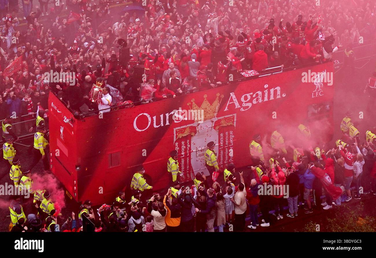 Liverpool's Virgil van Dijk holding the trophy as the open-top buses ...