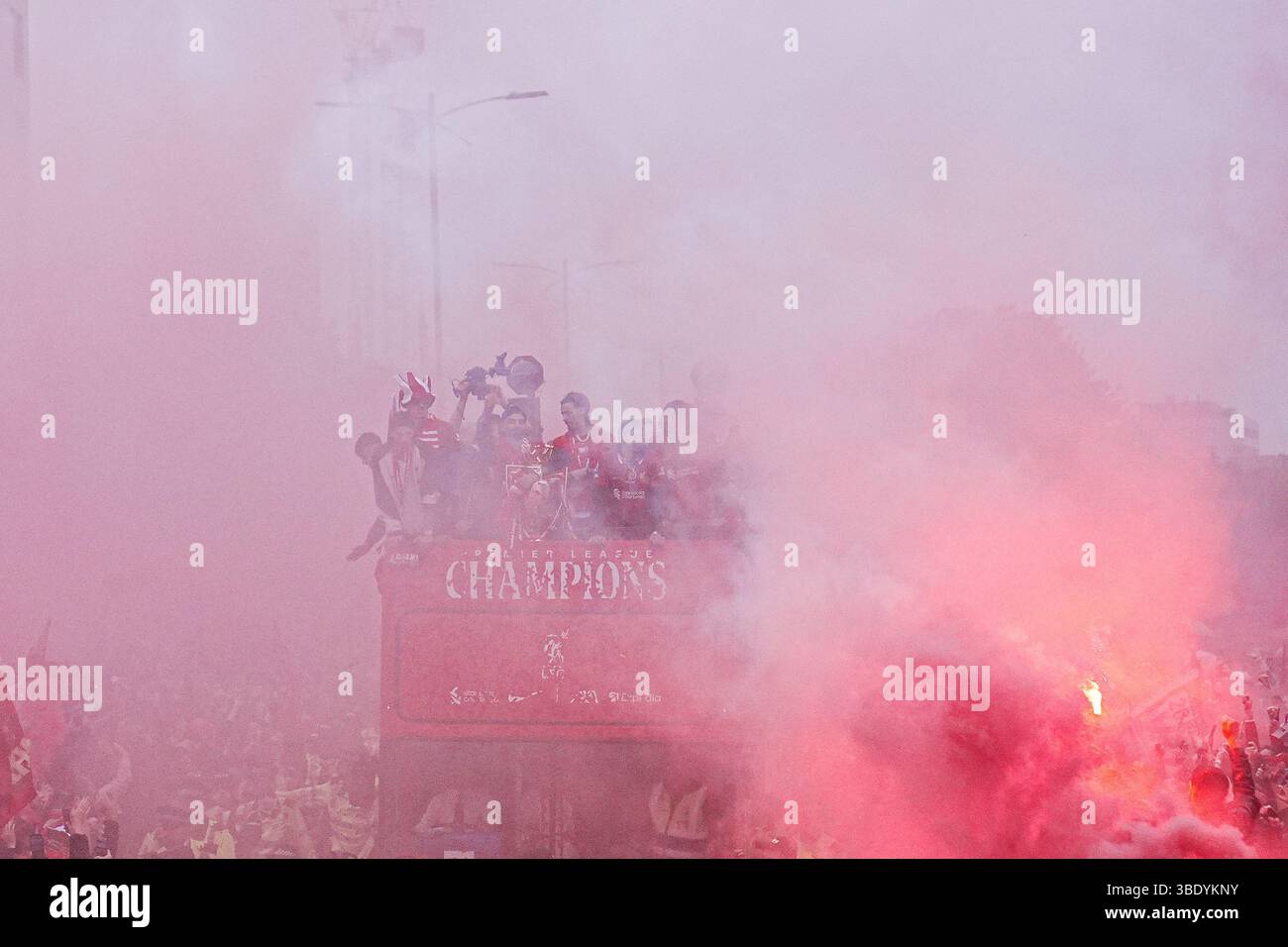 Liverpool fans watch on as the players advance on the open top bus ...