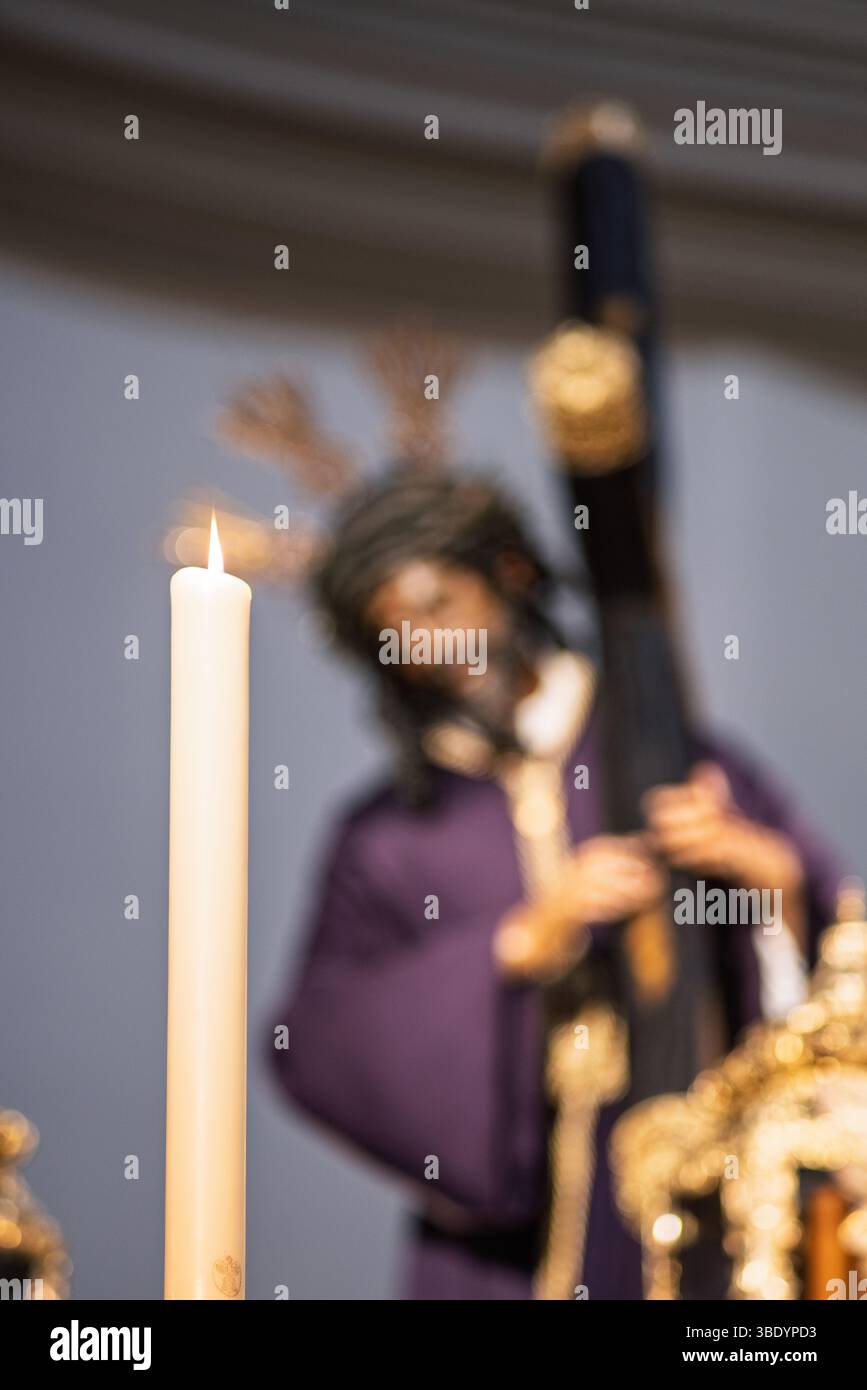 A lit candle illuminates the solemn atmosphere as the paso of Senor del ...