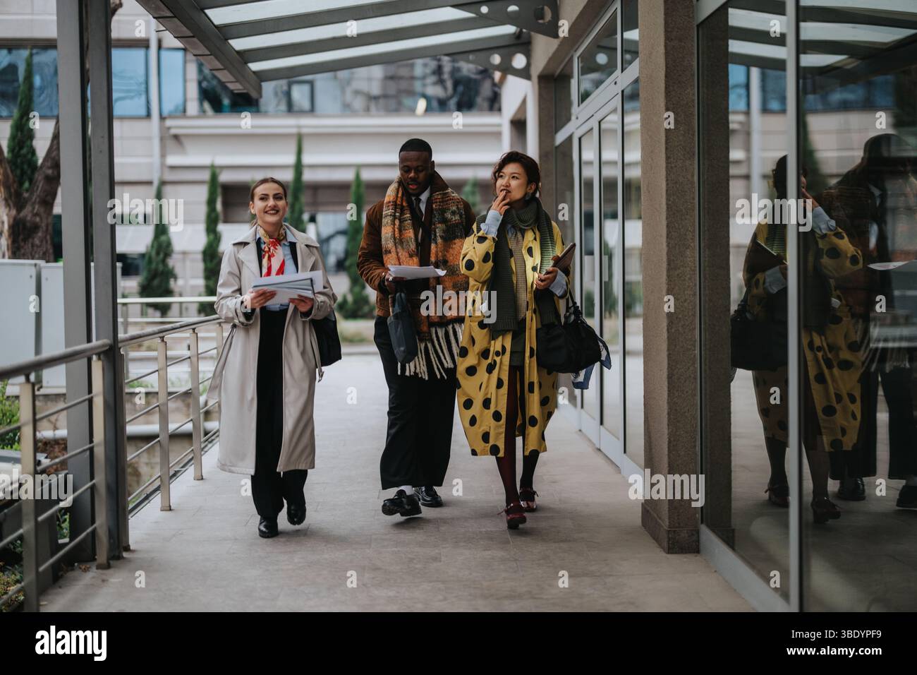Three diverse young professionals gathering hi-res stock photography ...