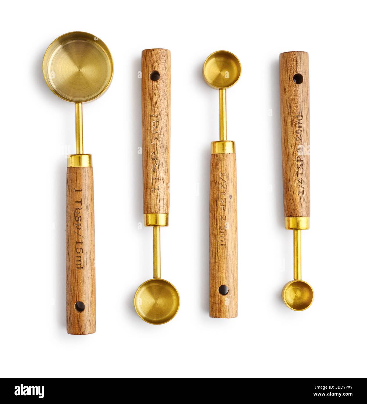 Golden measuring spoons with wooden handles isolated on white ...