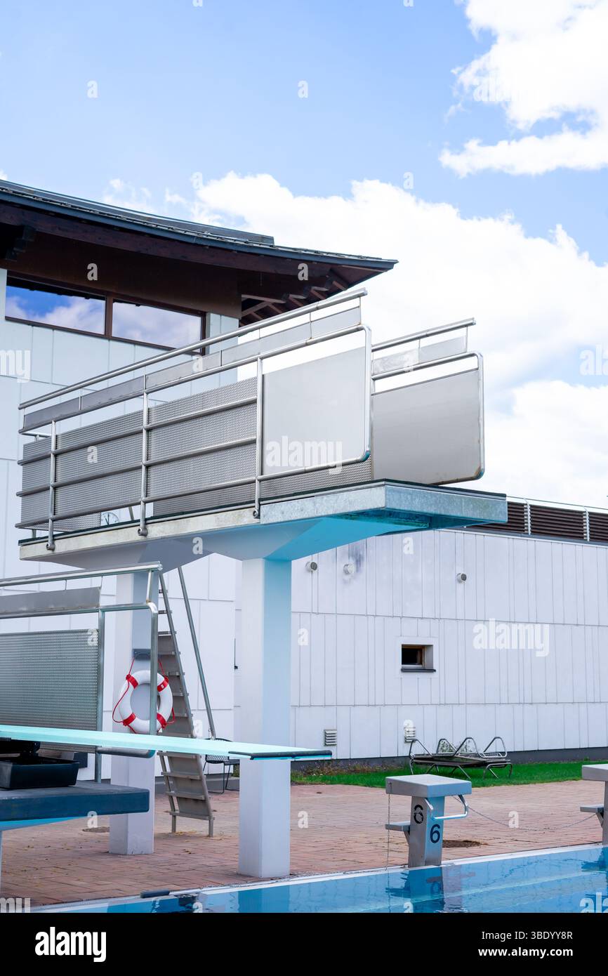 Side view of the diving board in an outdoor swimming pool against the ...