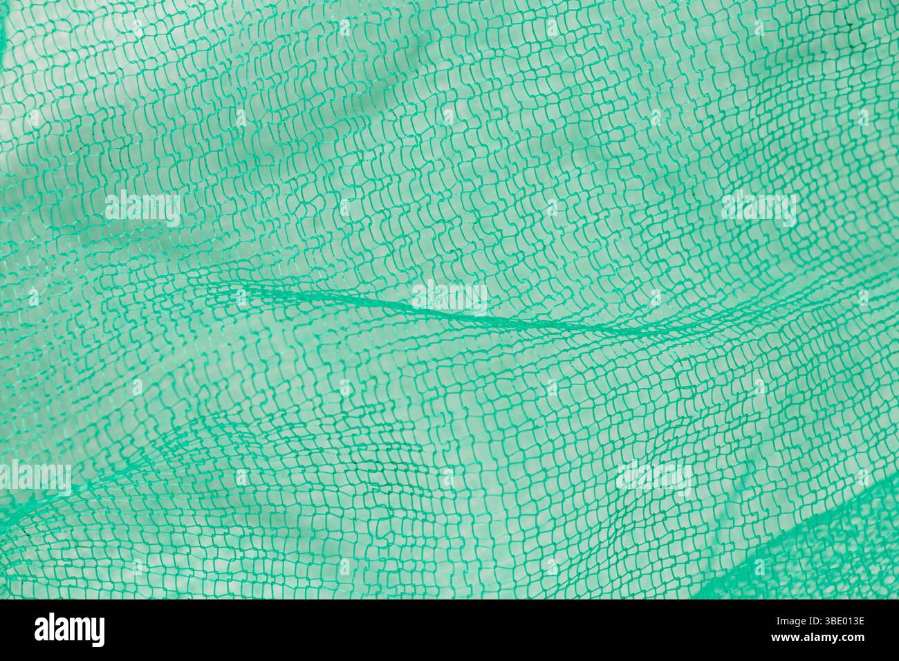 Green plastic mesh close-up, texture of packaging mesh for vegetables ...