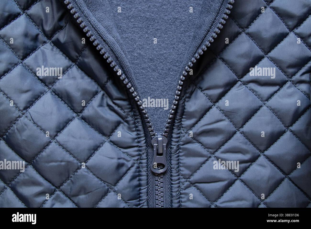 Men's blue quilted jacket with unzipped zipper, close-up of texture and ...