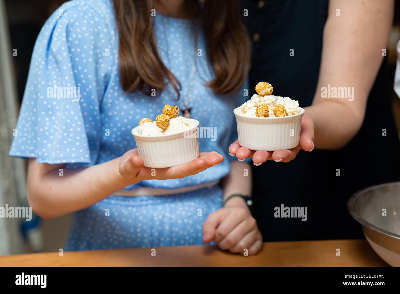 Two children presenting ramekins filled with creamy dessert topped with ...