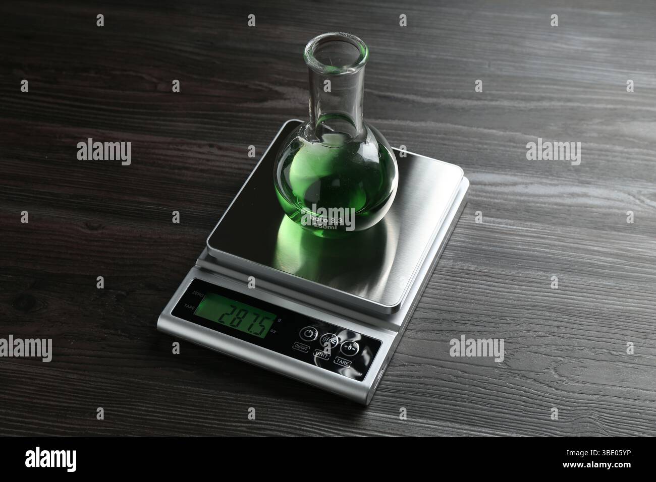 Laboratory scale with flask of sample on wooden table Stock Photo - Alamy