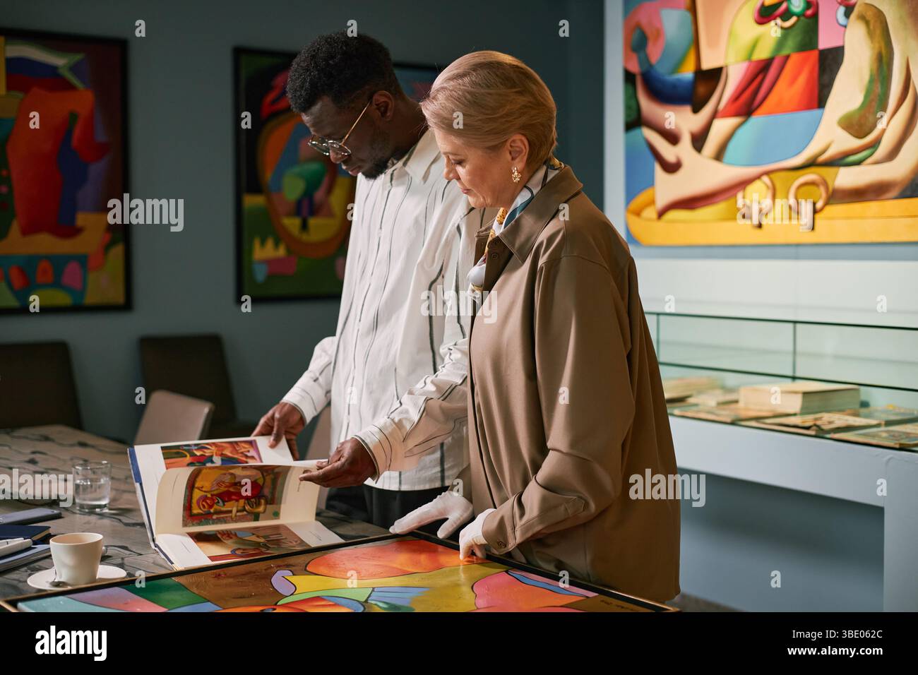 Senior Artists Examining Abstract Book in Art Gallery Stock Photo - Alamy