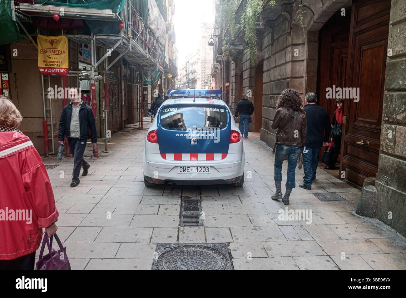 A small police car drives down a narrow street in Barcelona, Spain ...