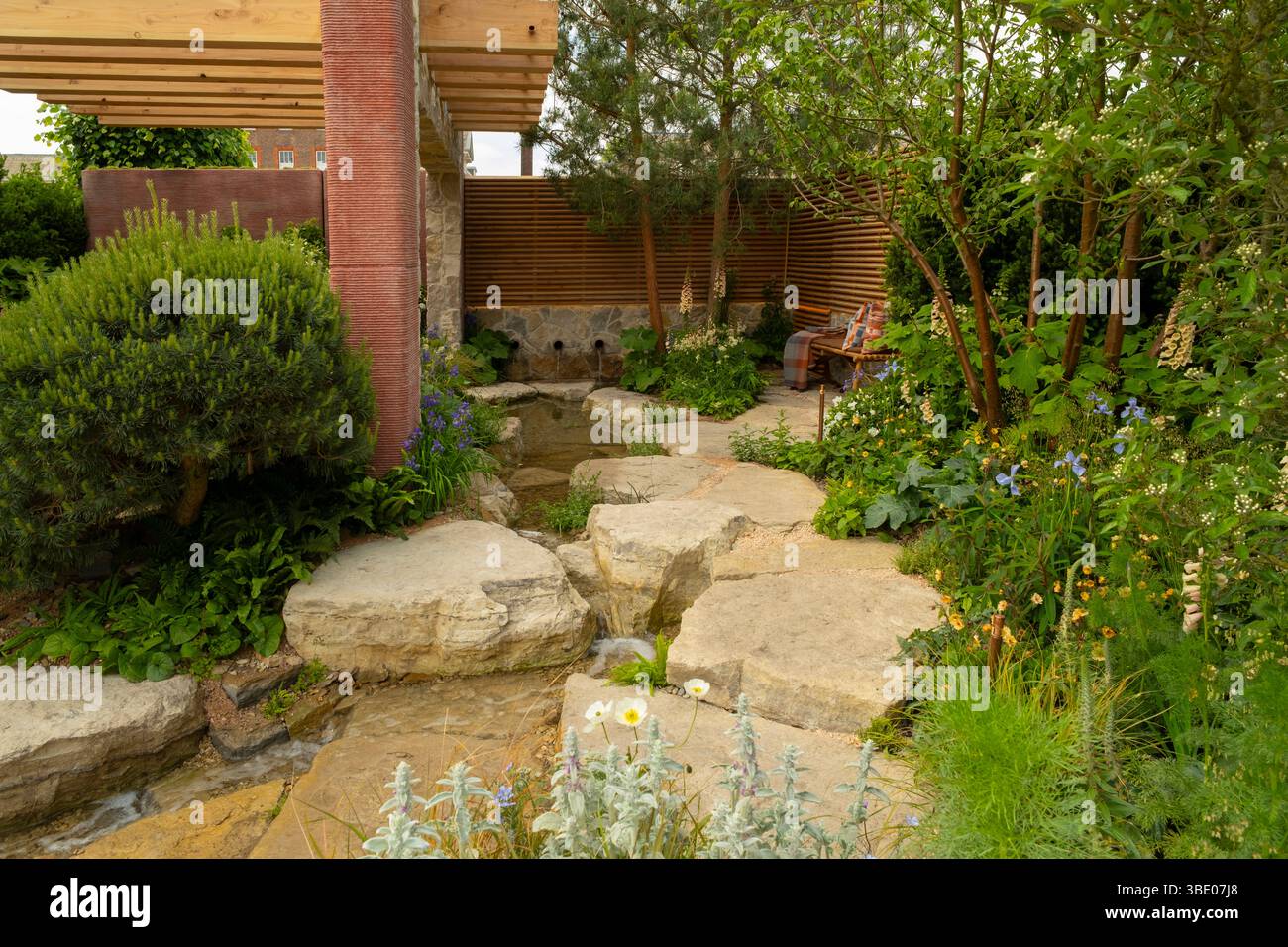 Overhead water troughs above a paved seating area funneling rainwater ...