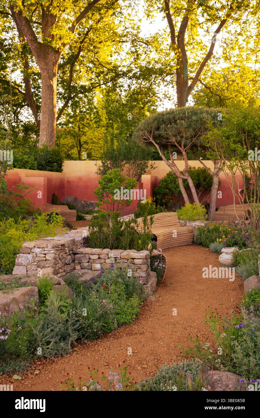 A path winding past stone walls, borders of Mediterannean planting and ...