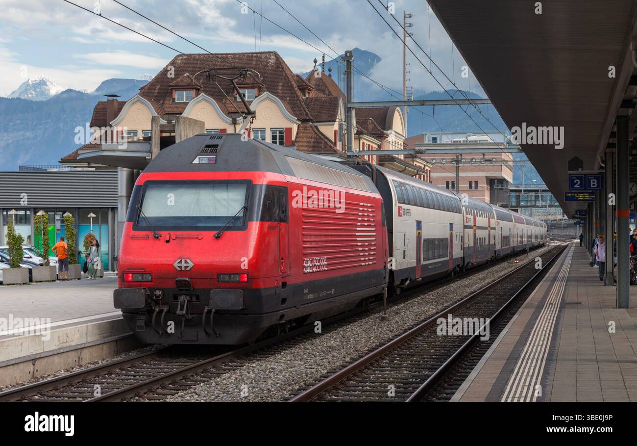 SBB Re 460 electric locomotive 460023 at Spiez railway station (Switzerland) with an double deck ...