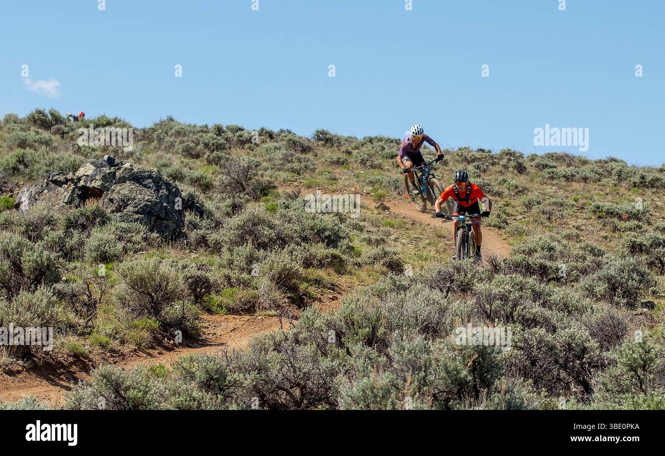May 25, 2025. Mountain bike cyclists cross through high desert terrain ...