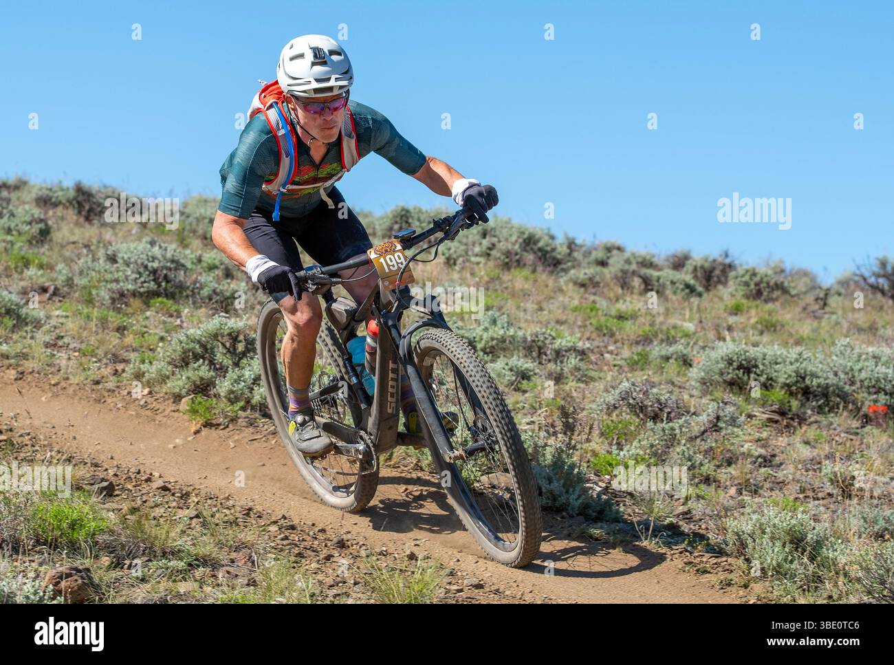 Gunnison, USA. 24th May, 2025. May 25, 2025. Mountain bike cyclist crosses through high desert ...