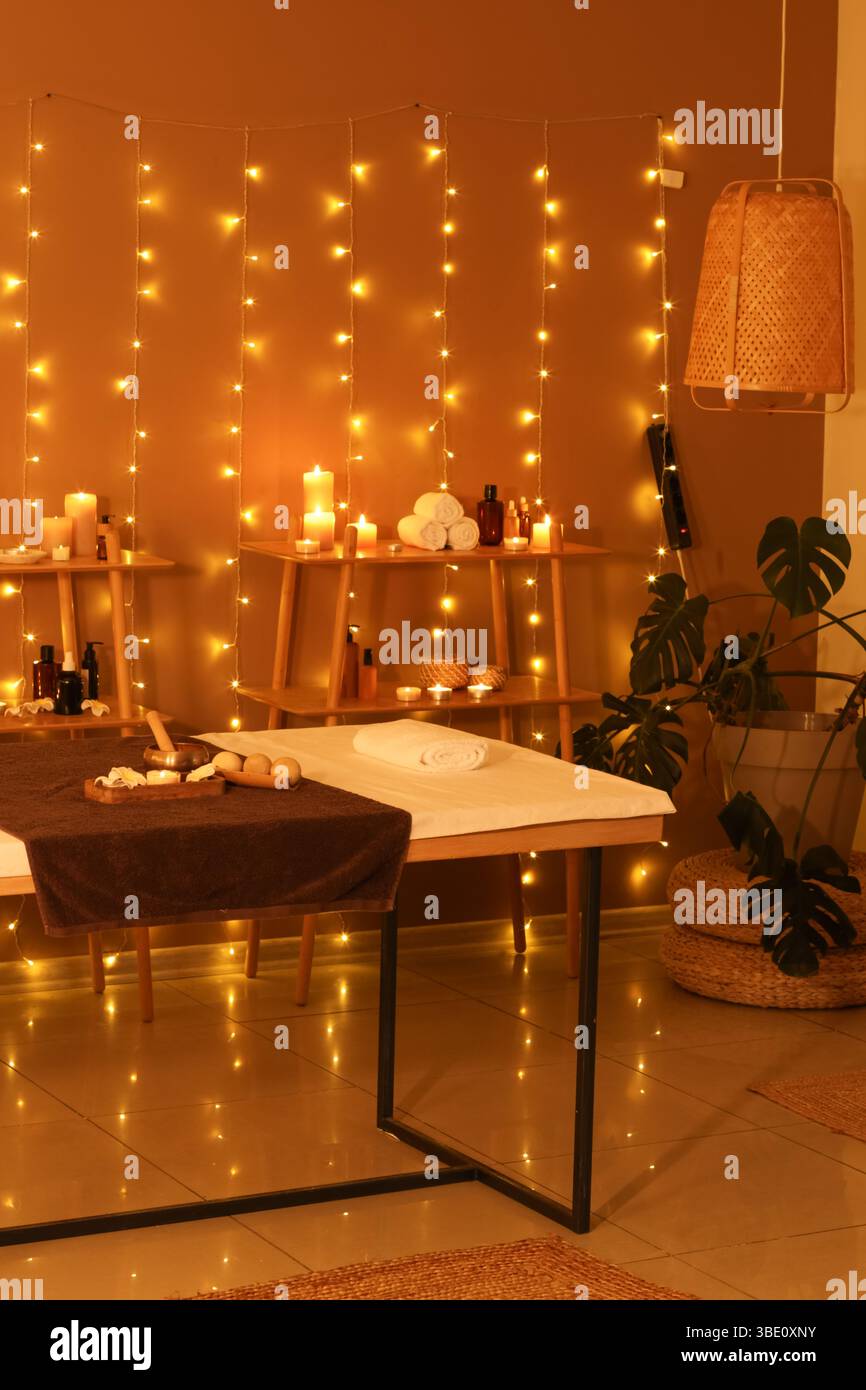 Interior of dark spa salon with couch, shelf units and glowing lights ...