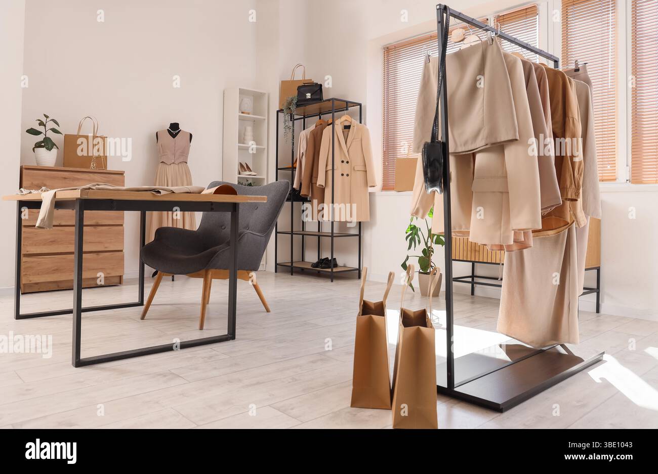 Interior of stylist's studio with clothes racks and workplace Stock ...