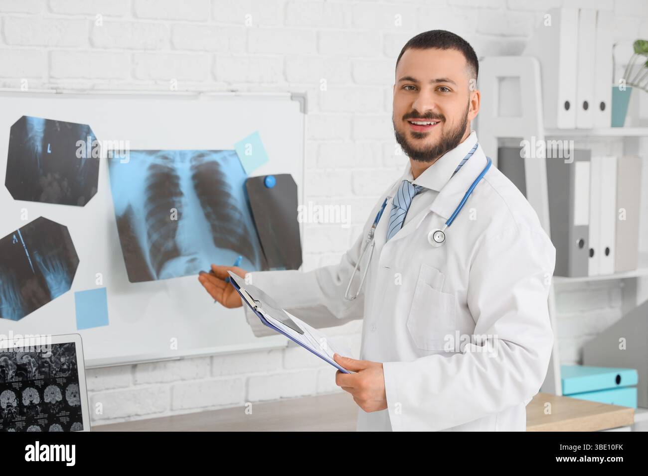 Male doctor working with clipboard and x-ray scans in clinic Stock Photo - Alamy
