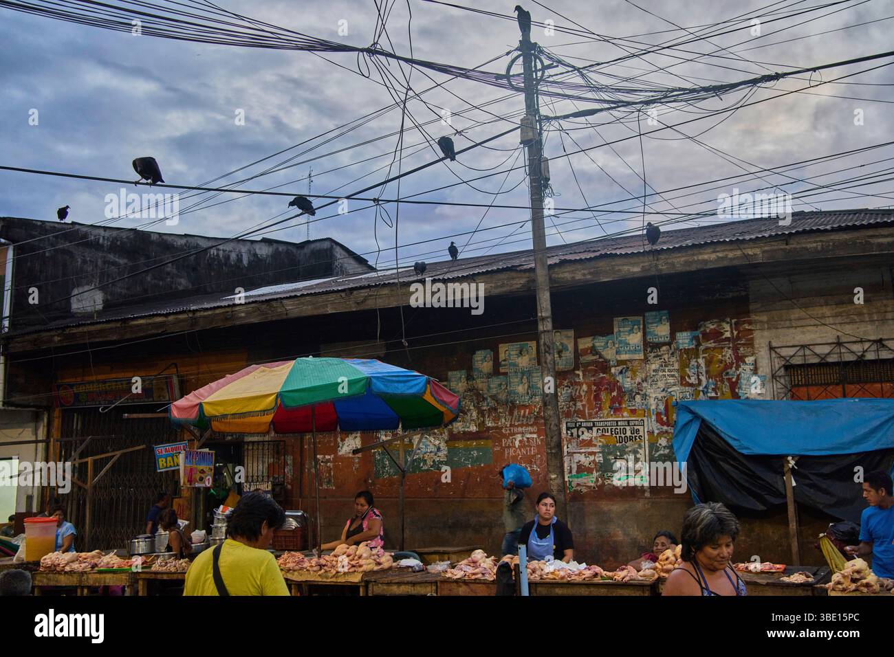 Chicken vendors at a street market wait for customers at their stalls ...