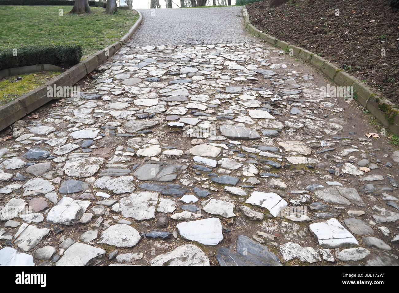 Cobblestone path leading through a serene park setting Stock Photo - Alamy