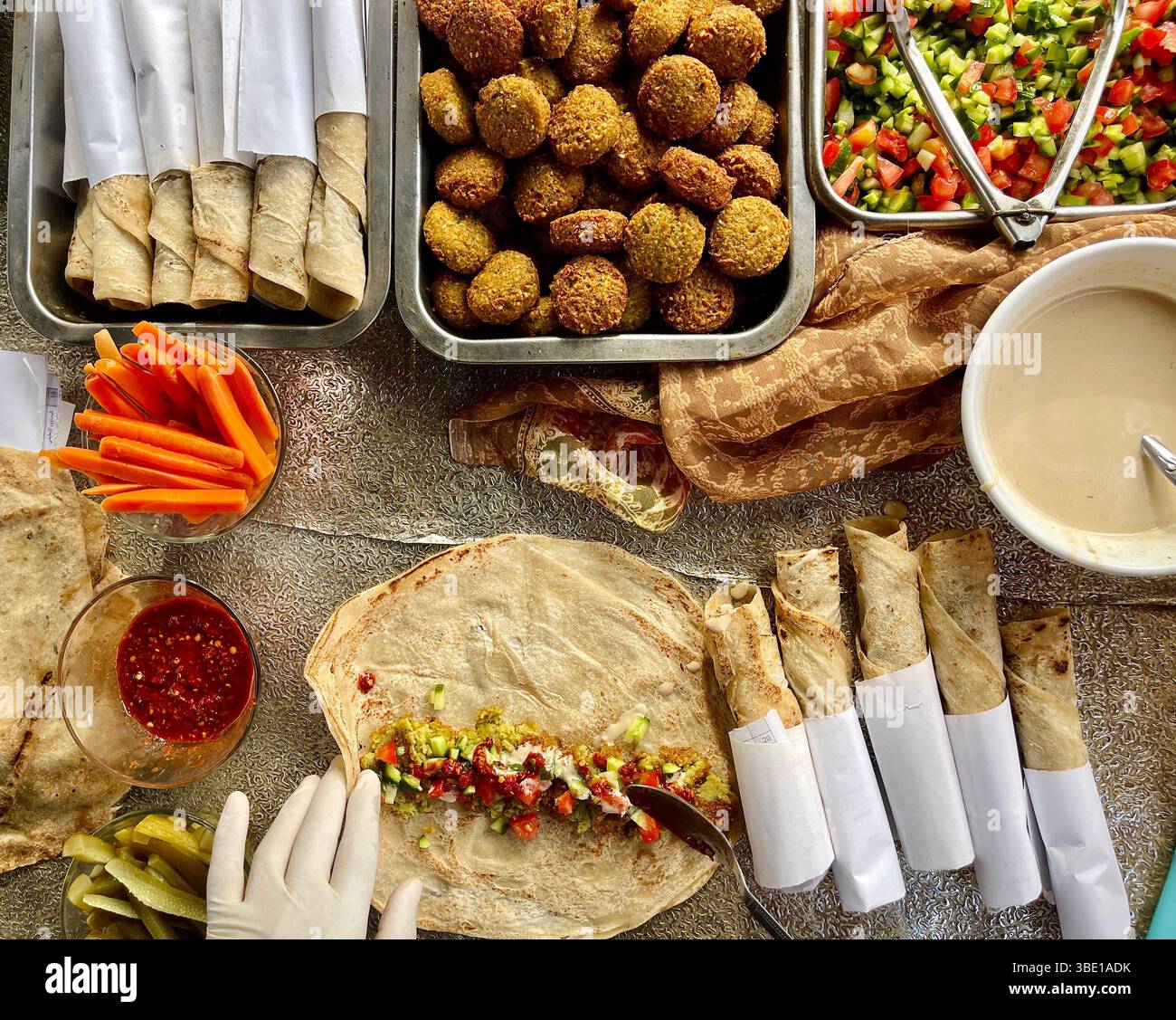 Making a traditional falafel sandwich with full toppings – tahini ...