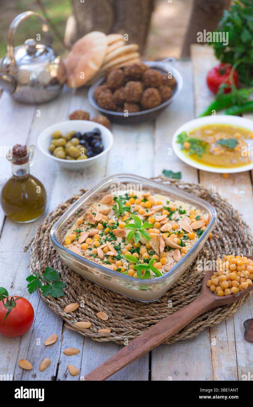 Hummus fatteh topped with nuts, chickpeas, and side dishes – classic ...