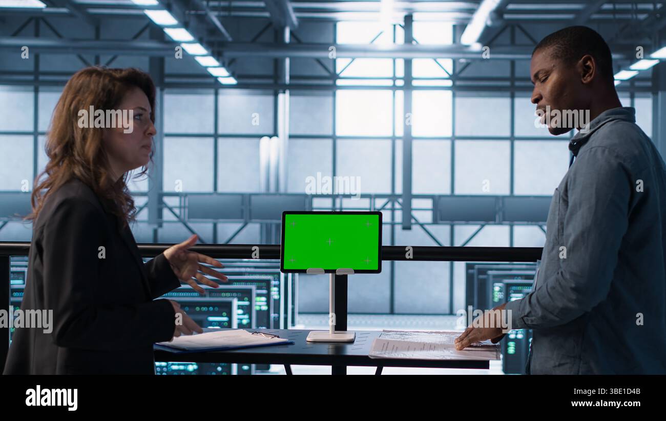 Data Center Team Using Mockup Green Screen Tablet Reviewing Paperwork Files And Security