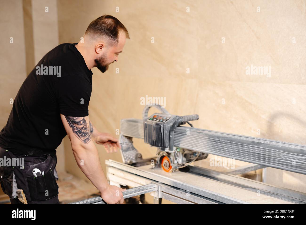 Construction worker is cutting ceramic tiles using professional machine ...