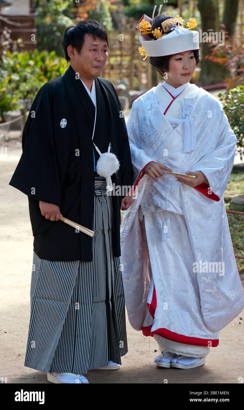A bride and groom dressed in traditional Japanese kimono partake in a ...