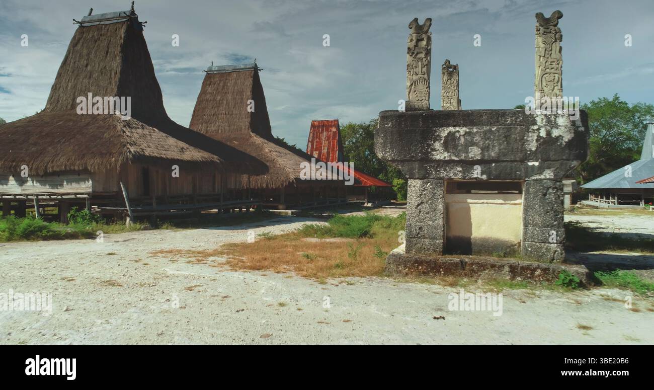 Ancient stone tomb with carved pillars standing in front of traditional ...
