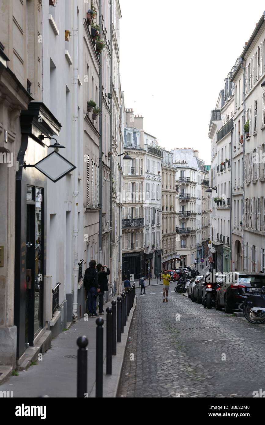 People on Narrow Parisian Cobblestone Street with Parked Cars and ...