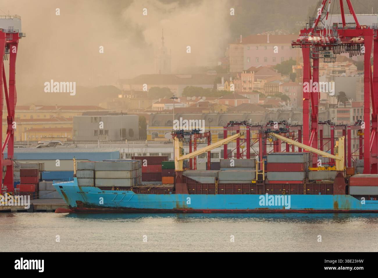 Blue container ship docked at Lisbon port, red cranes and stacks of ...