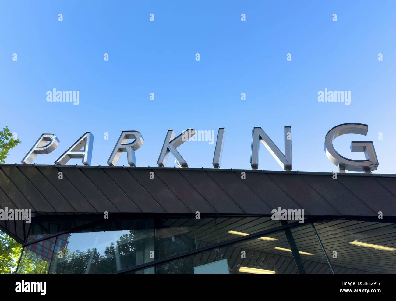 PARKING word sign on the roof. Metallic letters text at the building ...
