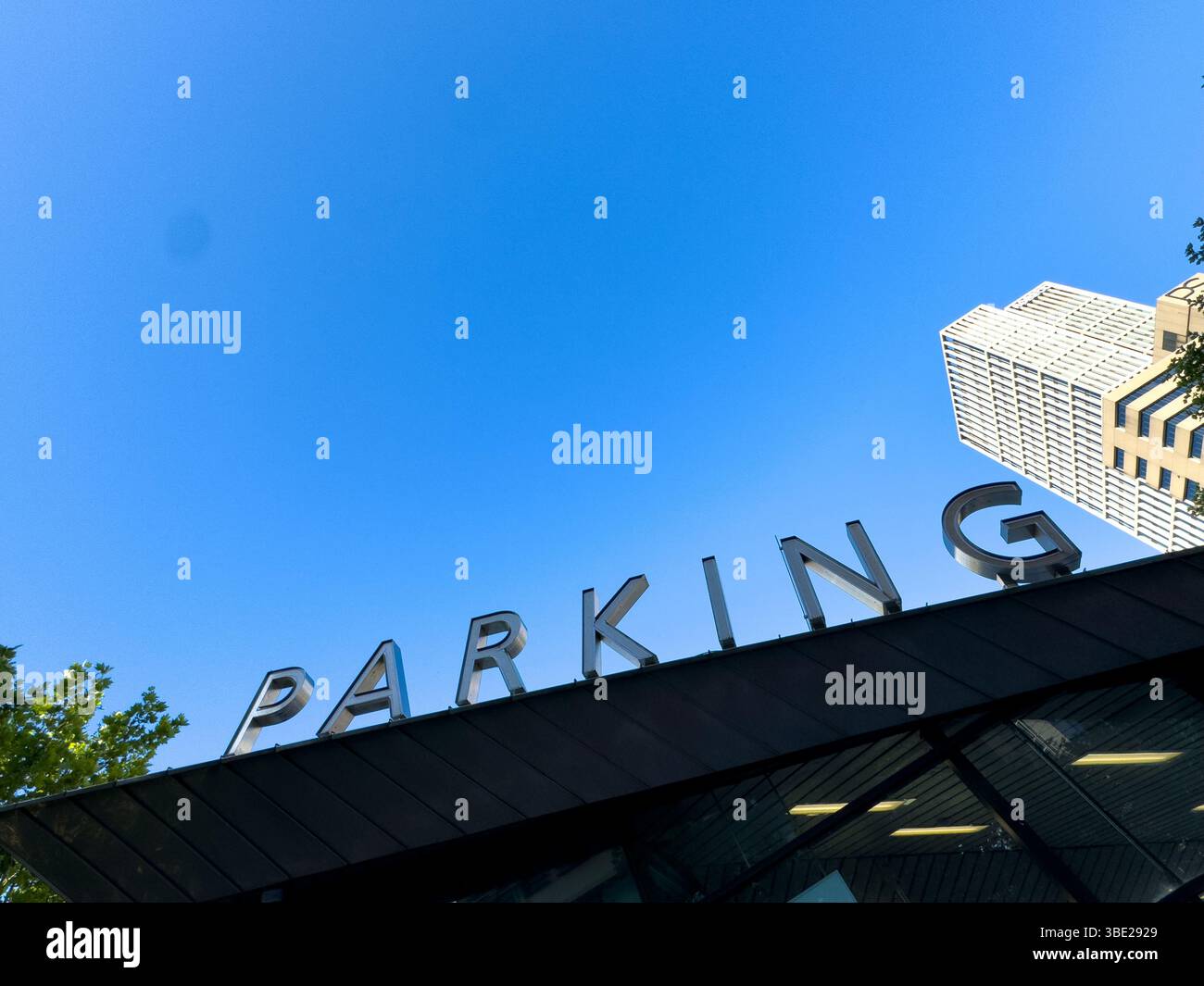 PARKING word sign on the roof. Metallic letters text at the building ...