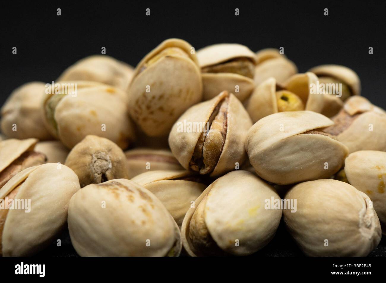 Roasted pistachio nuts in shell on black background (Antep Fistigi ...