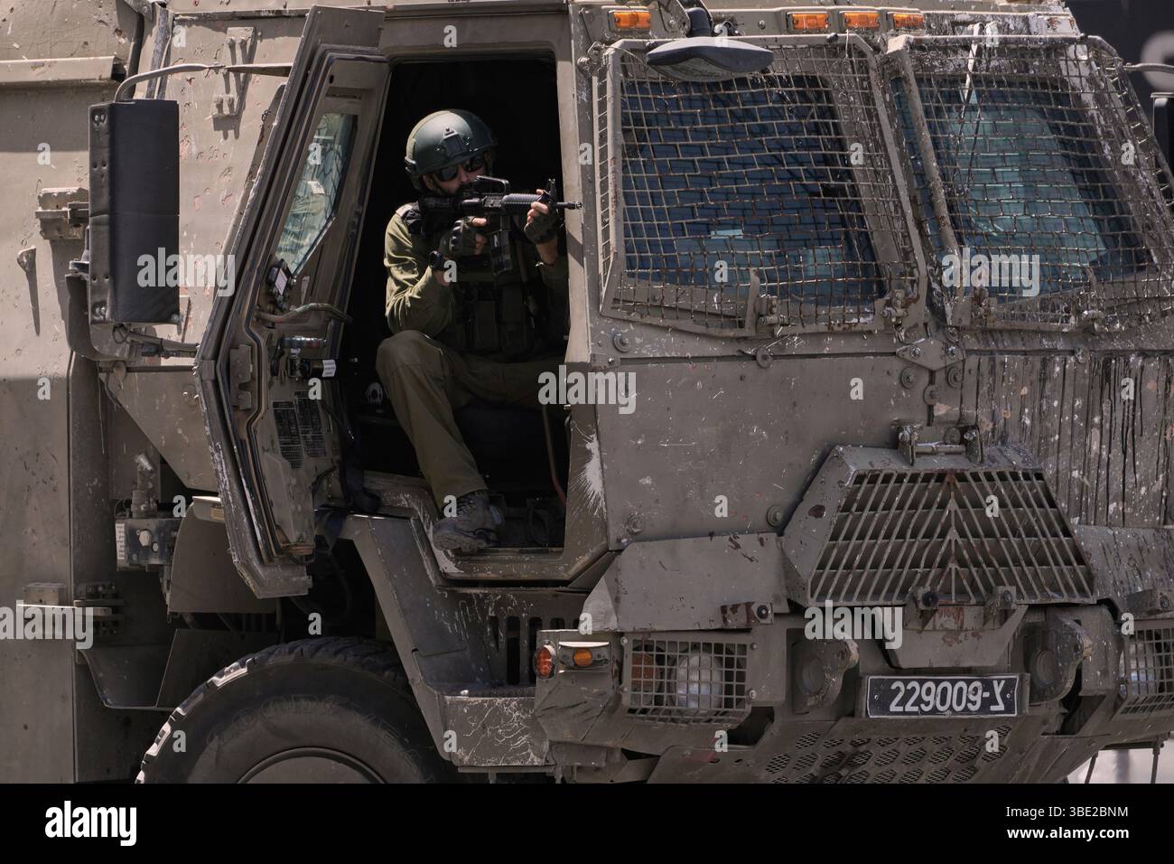 An Israeli soldier aims his weapon during a military raid in the West ...