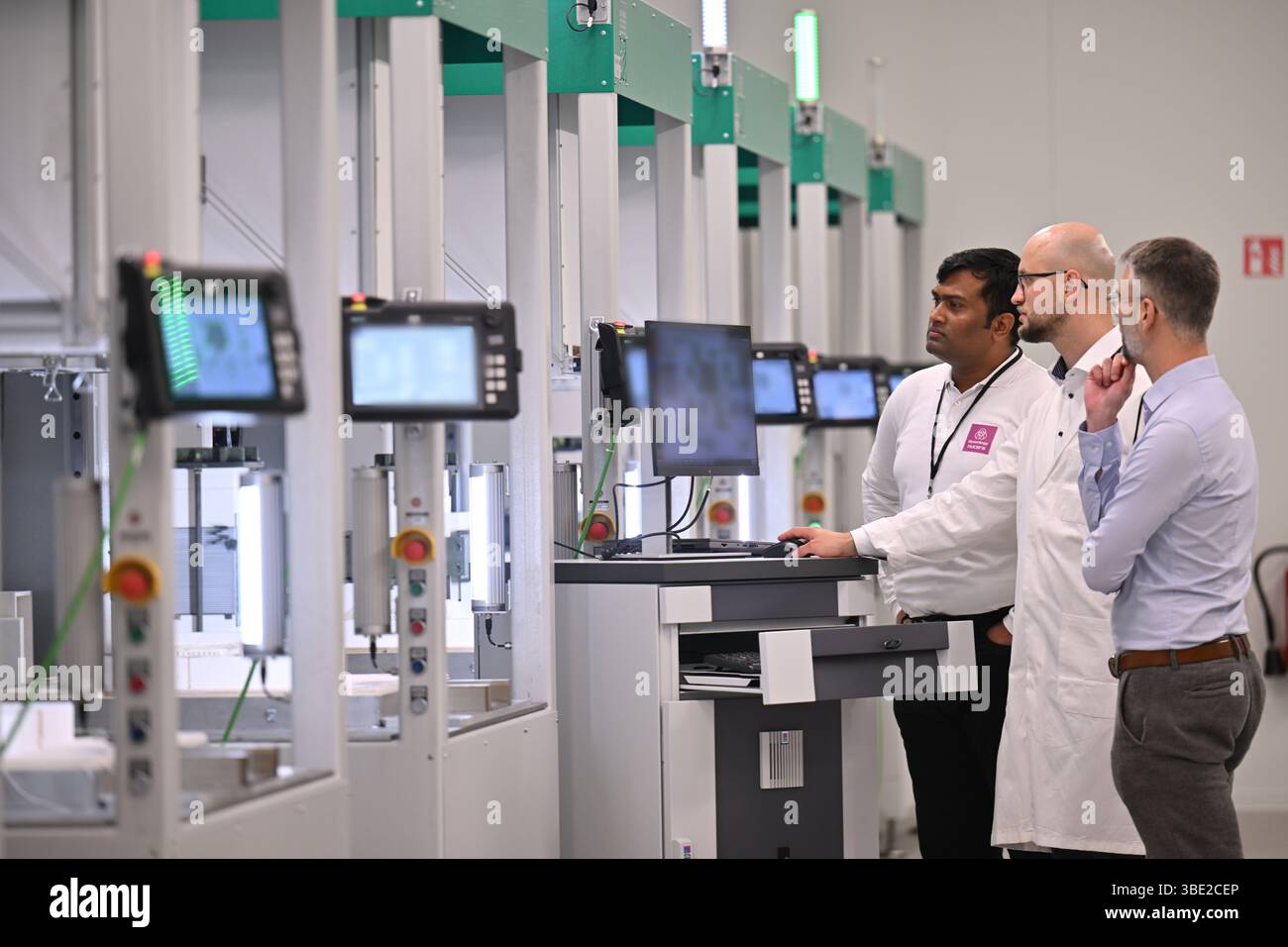 Arnstadt, Germany. 27th May, 2025. Employees stand at a workstation in ...