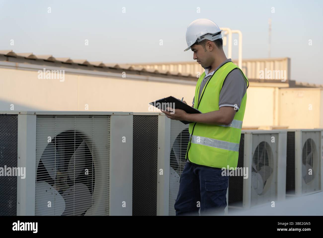Asian maintenance engineer works on the roof of factory. contractor ...
