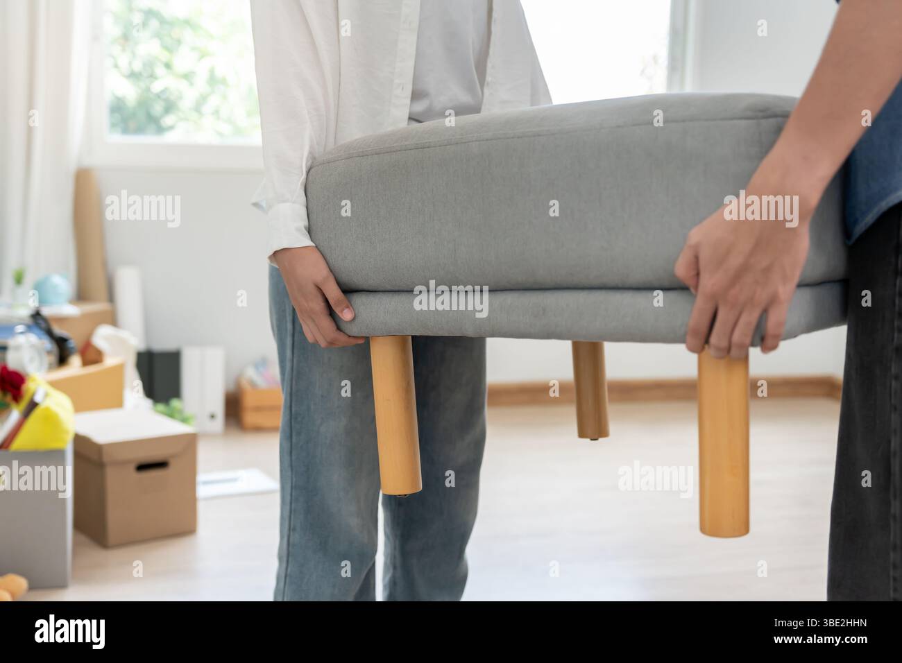 Moving house, relocation. Couple help set sofa and move furniture for ...