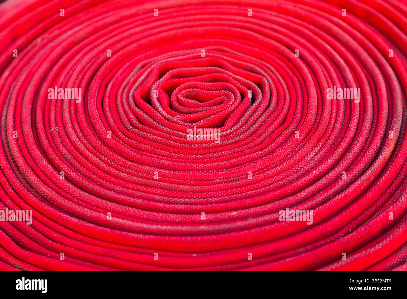 Twisted fire hose red color close up Stock Photo - Alamy