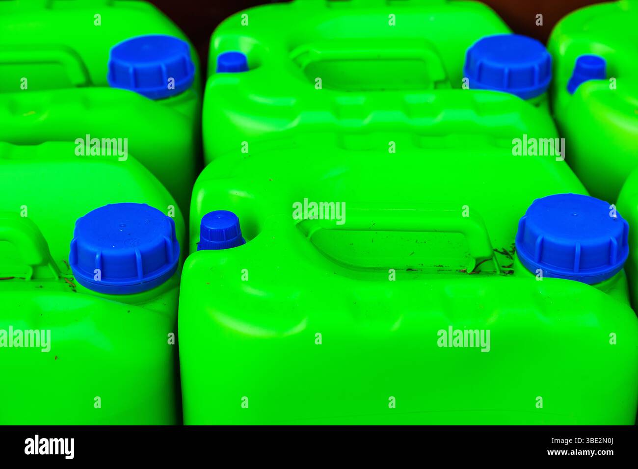 Green plastic cans with blue caps, close up Stock Photo - Alamy