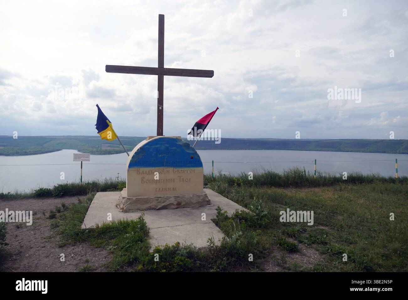 The flags of Ukraine and OUN-UPA flutter in the wind at the cross on ...