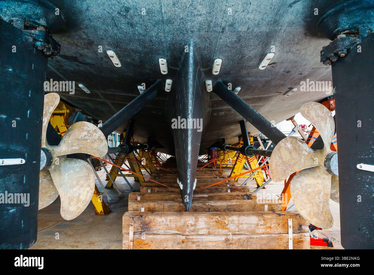 The back of a large motor yacht, standing on wooden blocks in a dry ...