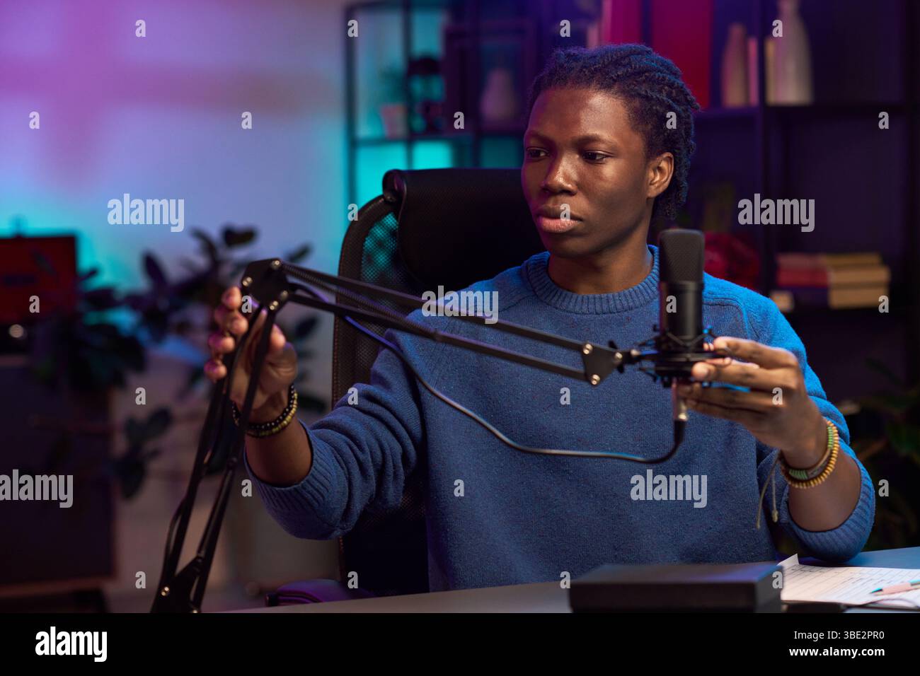Man adjusting microphone in contemporary recording studio. Background ...