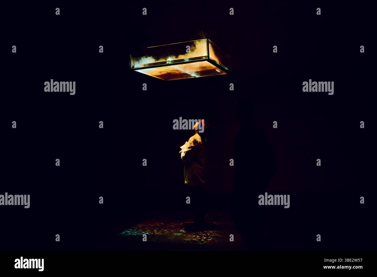 woman gazes up at a glowing ceiling tank at the Museum of Contemporary ...