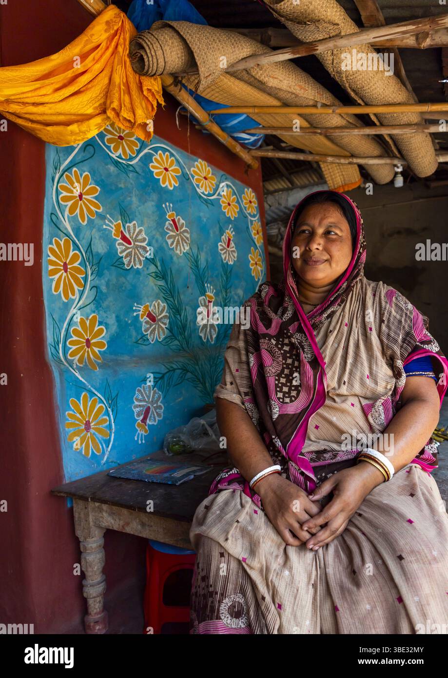 Bangladeshi woman in front of a traditional wall painting in a house, Rajshahi Division, Tikoil ...